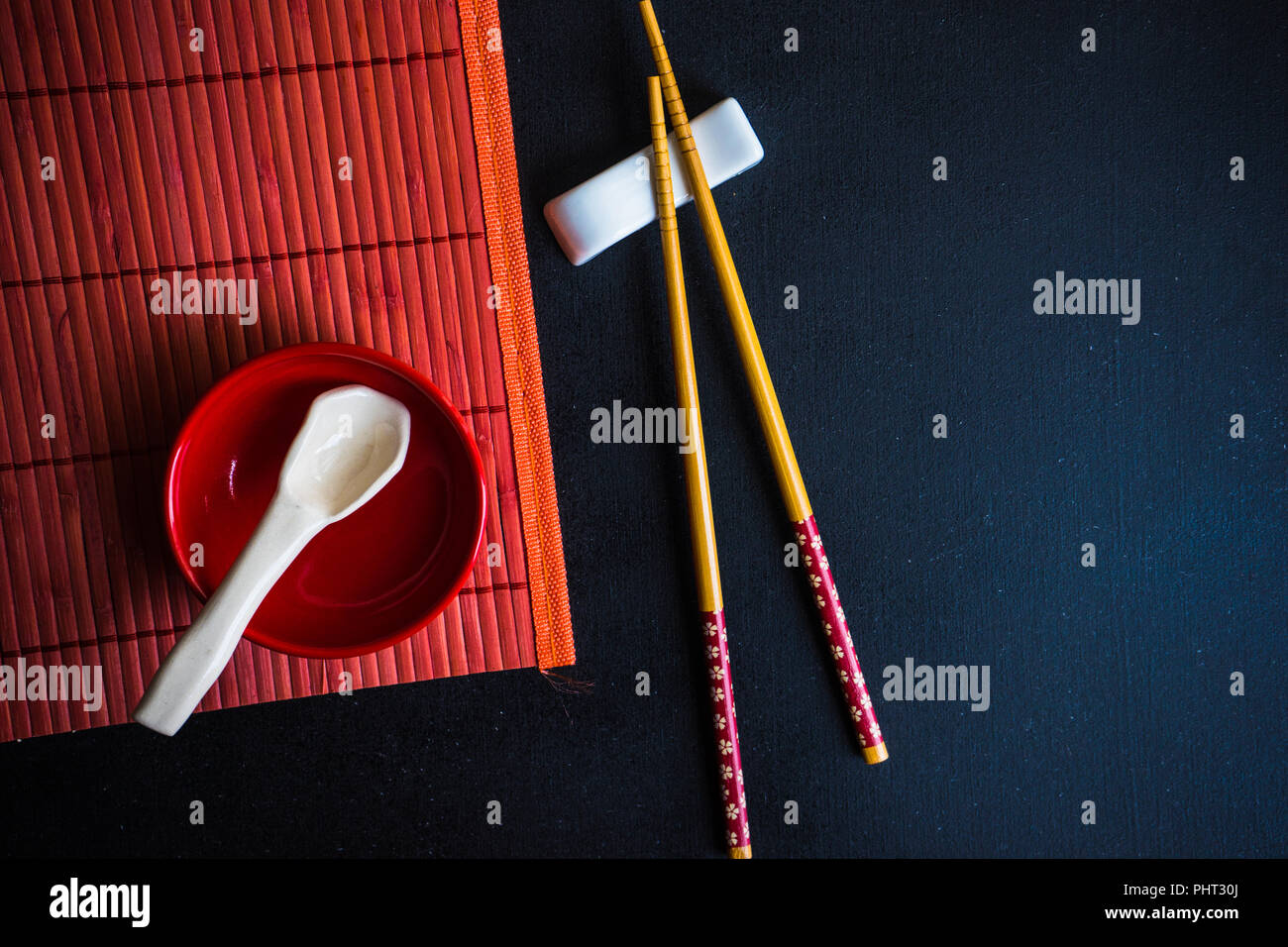 Table setting in red color for asian cuisine dinner with chopsticks ...