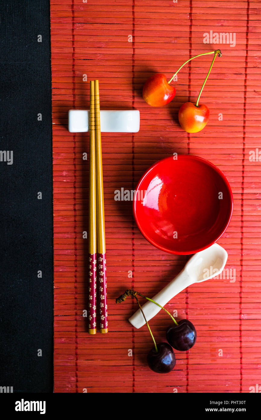 Table setting in red color for asian cuisine dinner with chopsticks ...