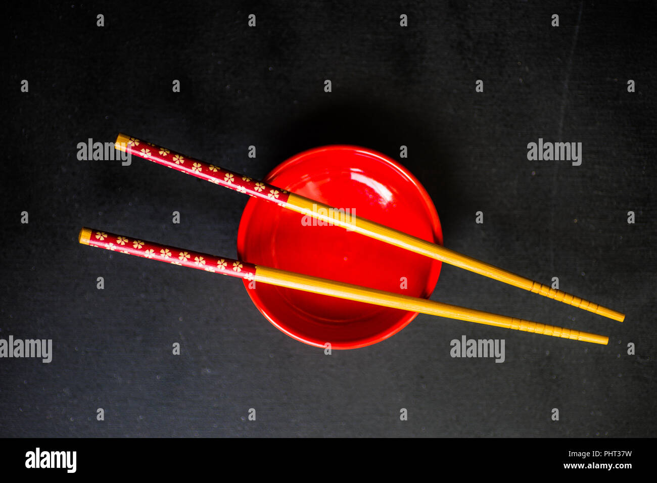 Table setting in red color for asian cuisine dinner with chopsticks ...