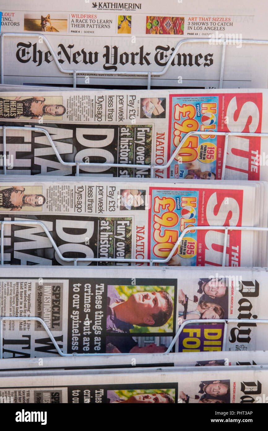 the new york times, the sun and the daily mail newspapers in a rack at ...