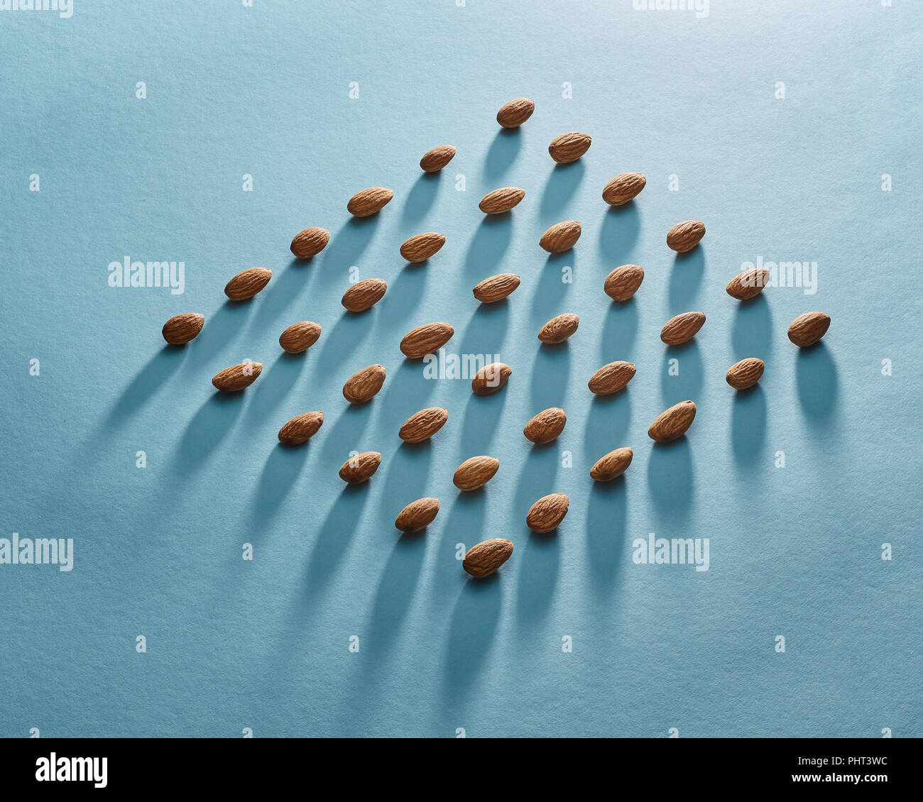 Beautiful pattern of almonds on paper blue background Stock Photo - Alamy