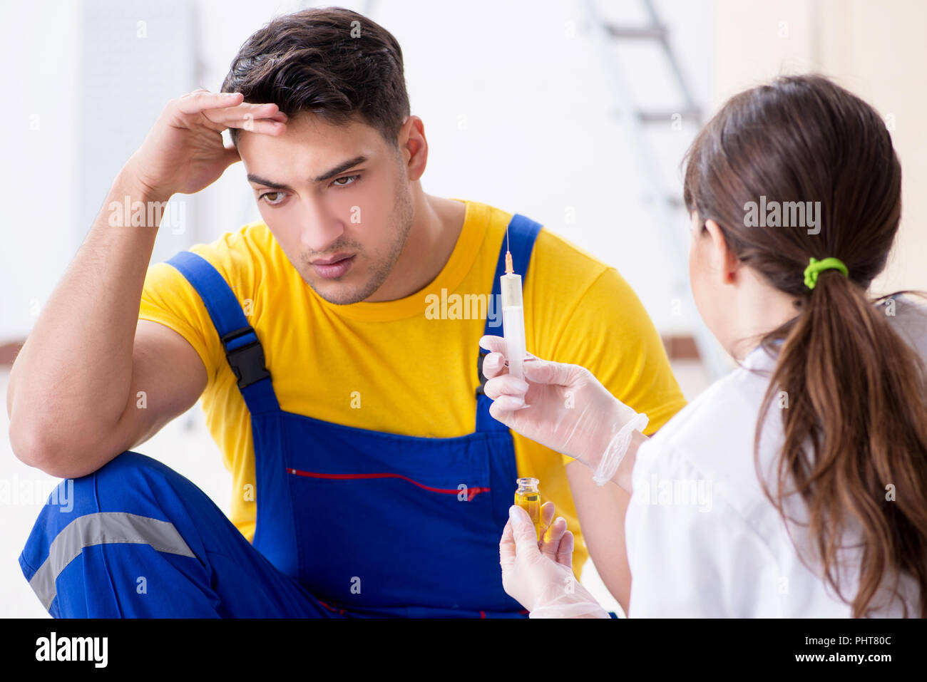 Doctor helping injured worker at construction site Stock Photo - Alamy
