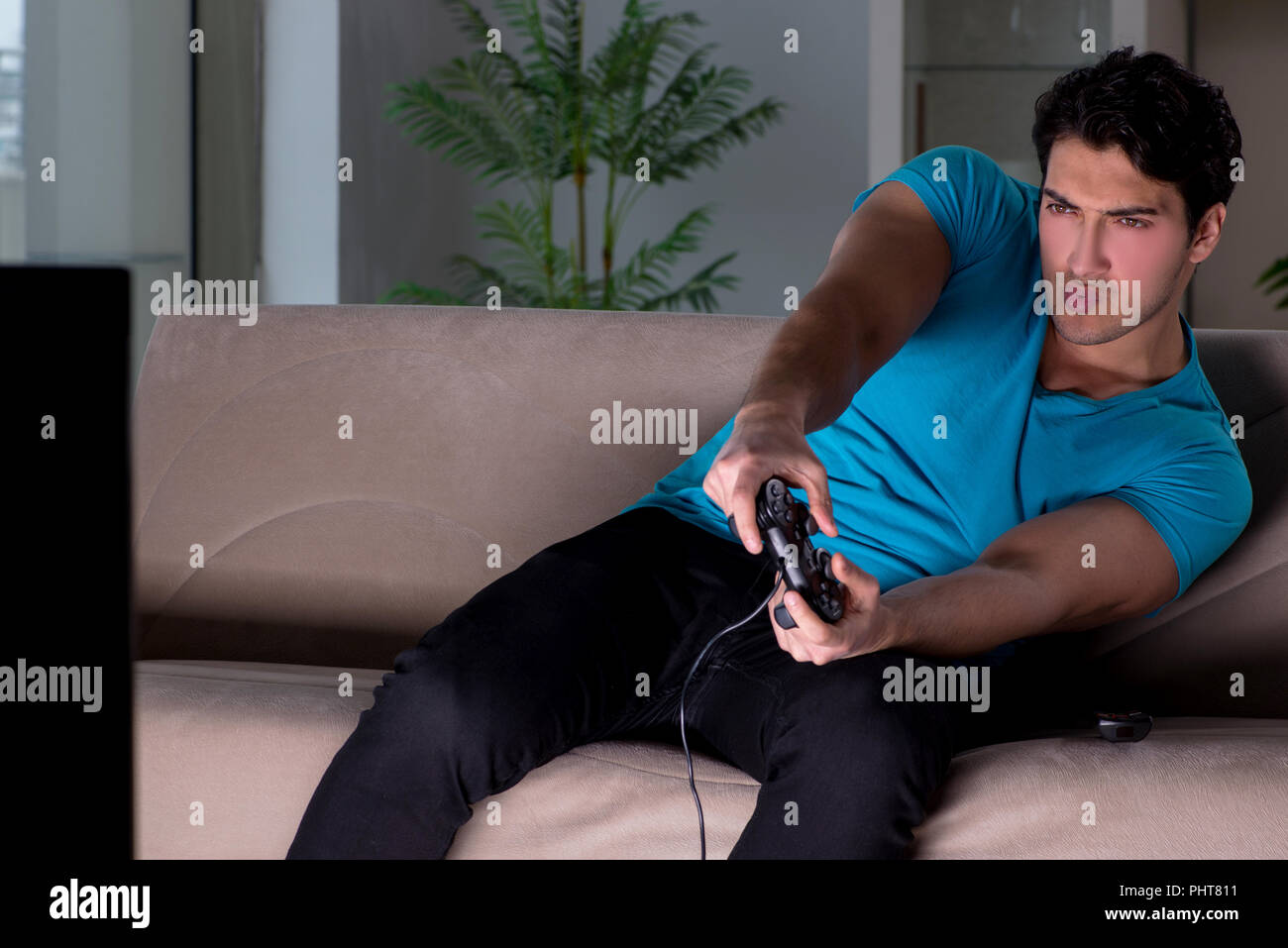 Young man playing computer games late at night Stock Photo - Alamy