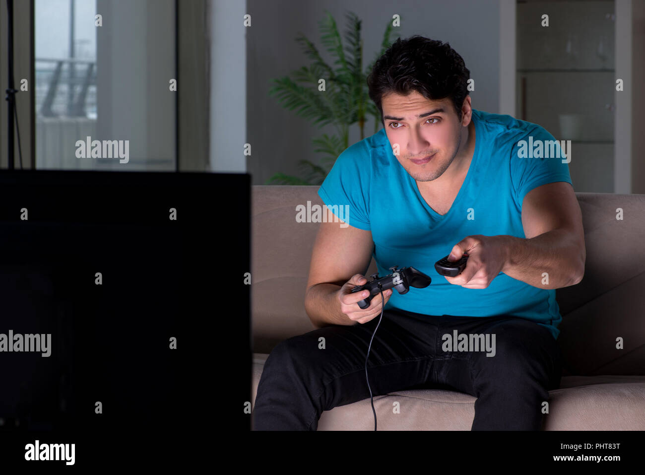 Young man playing computer games late at night Stock Photo - Alamy