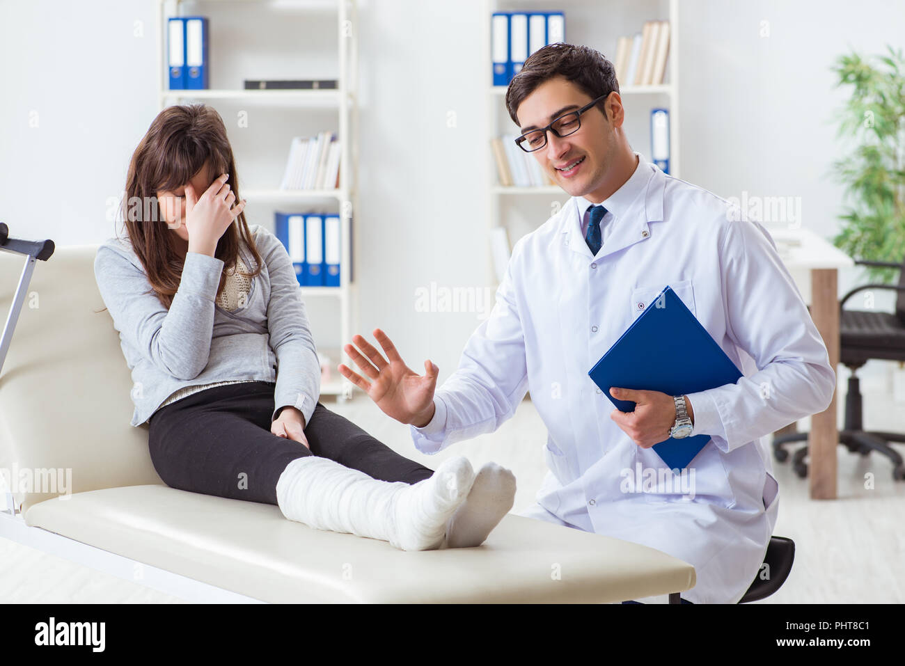 Doctor examining patient with broken leg Stock Photo - Alamy