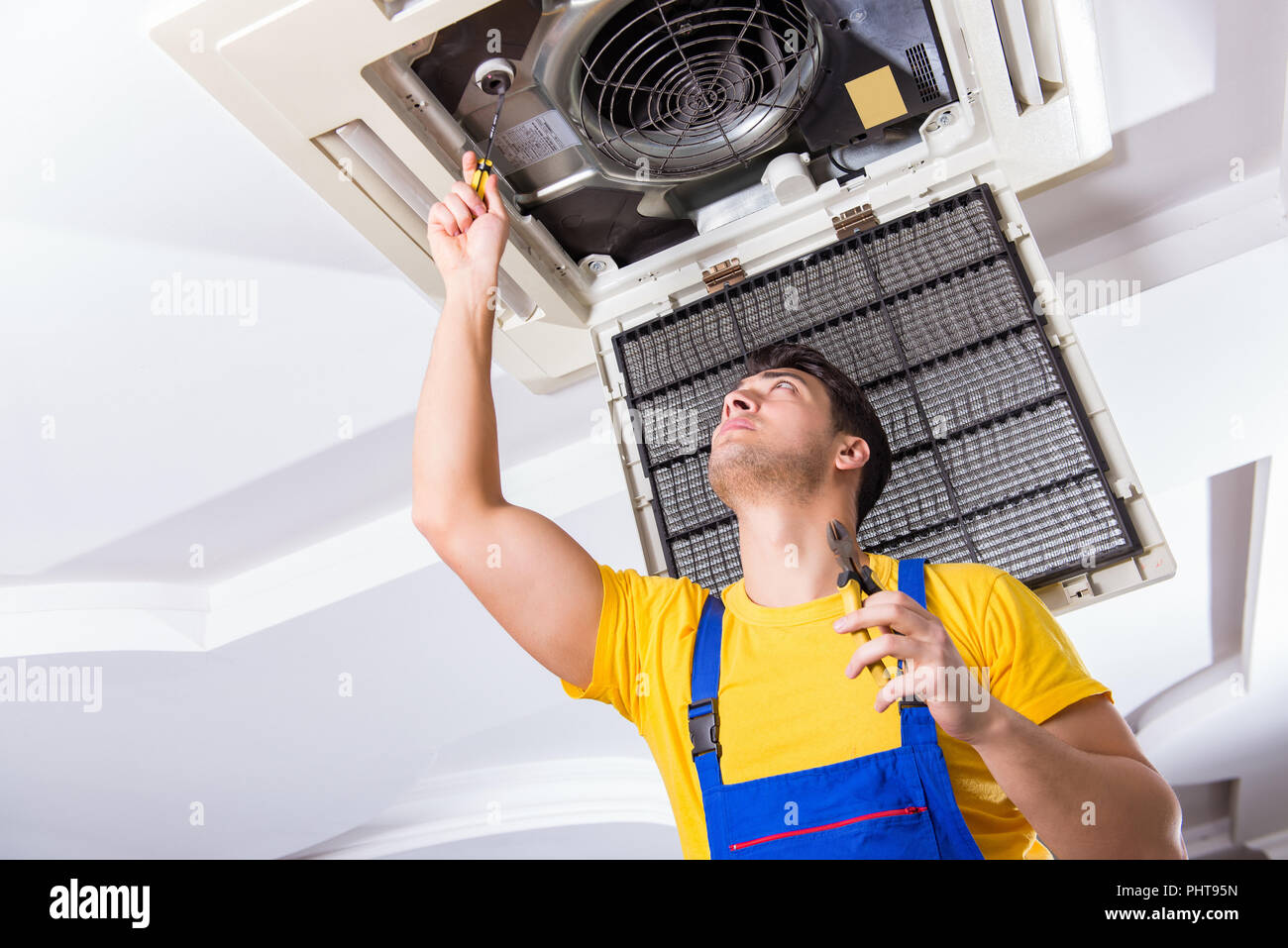 Repairman repairing ceiling air conditioning unit Stock Photo - Alamy