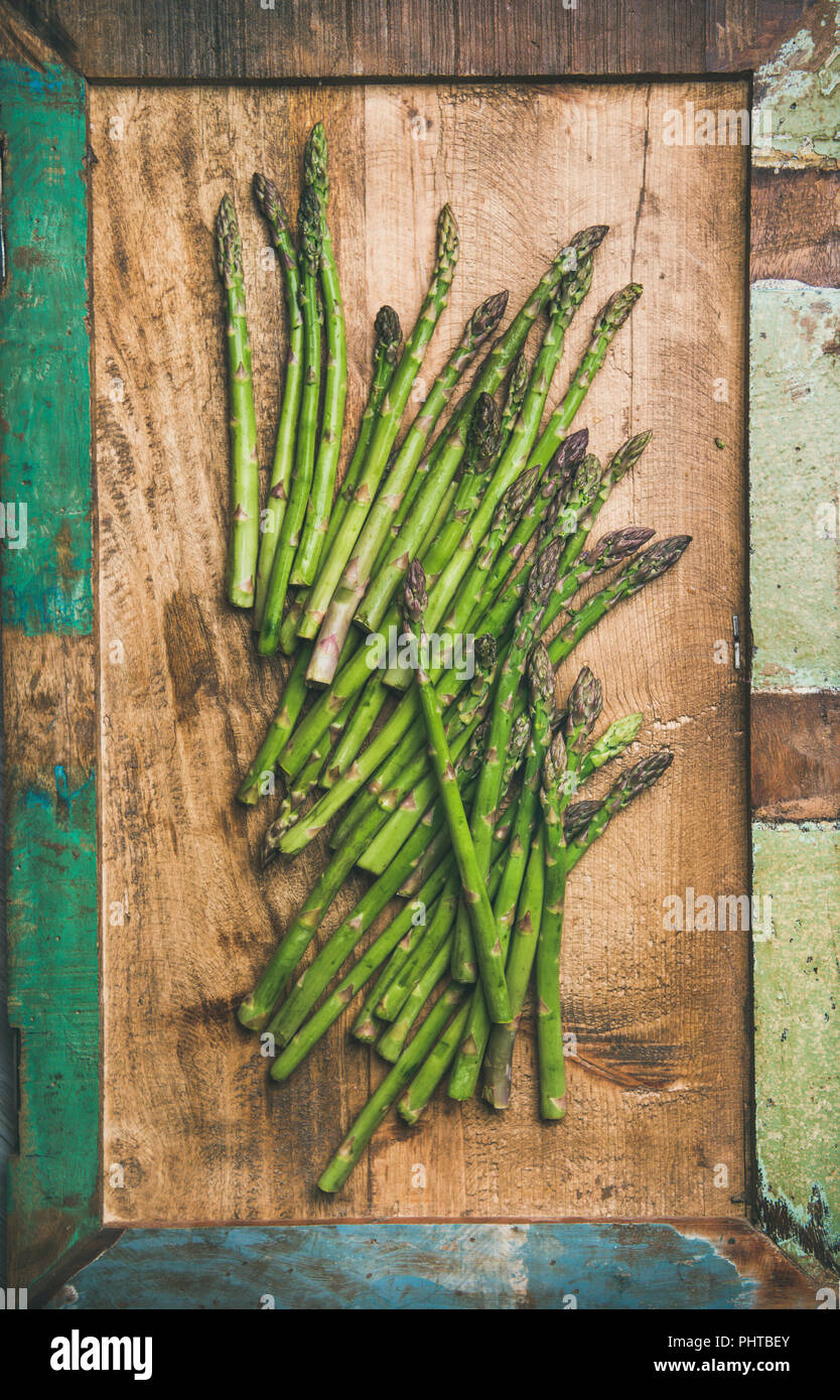 Seasonal harvest produce . Flat-lay of raw uncooked green asparagus ...