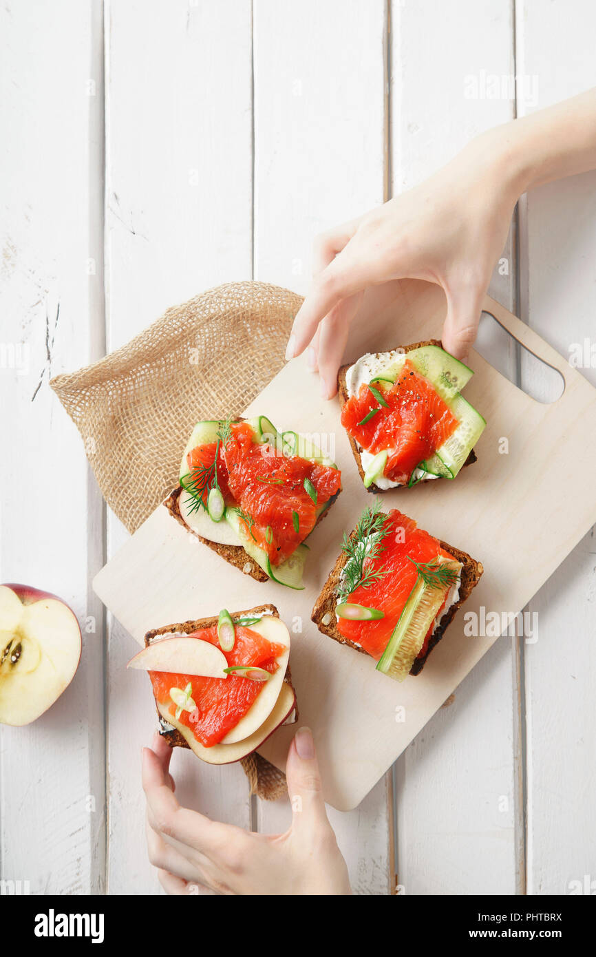 Danish traditional snack smorrebrod with salmon, cucumbers and cream ...