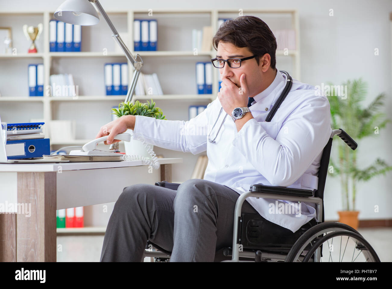 Disabled doctor on wheelchair working in hospital Stock Photo - Alamy