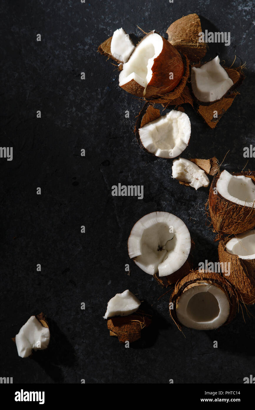 Cracked coconut arranged on dark textured background. Hard light Stock ...