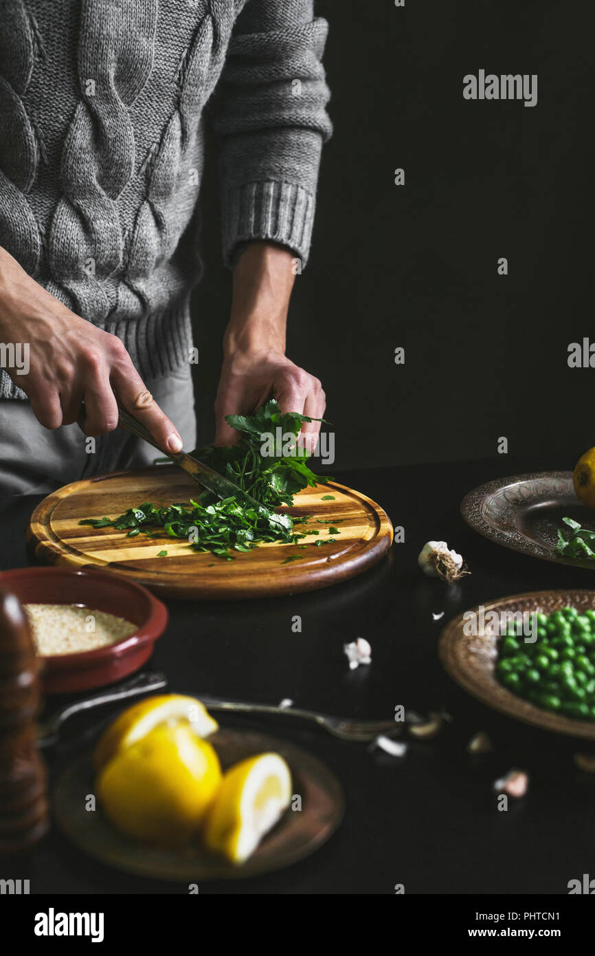 A mans hands chopping parsley while preparing a meal Stock Photo - Alamy