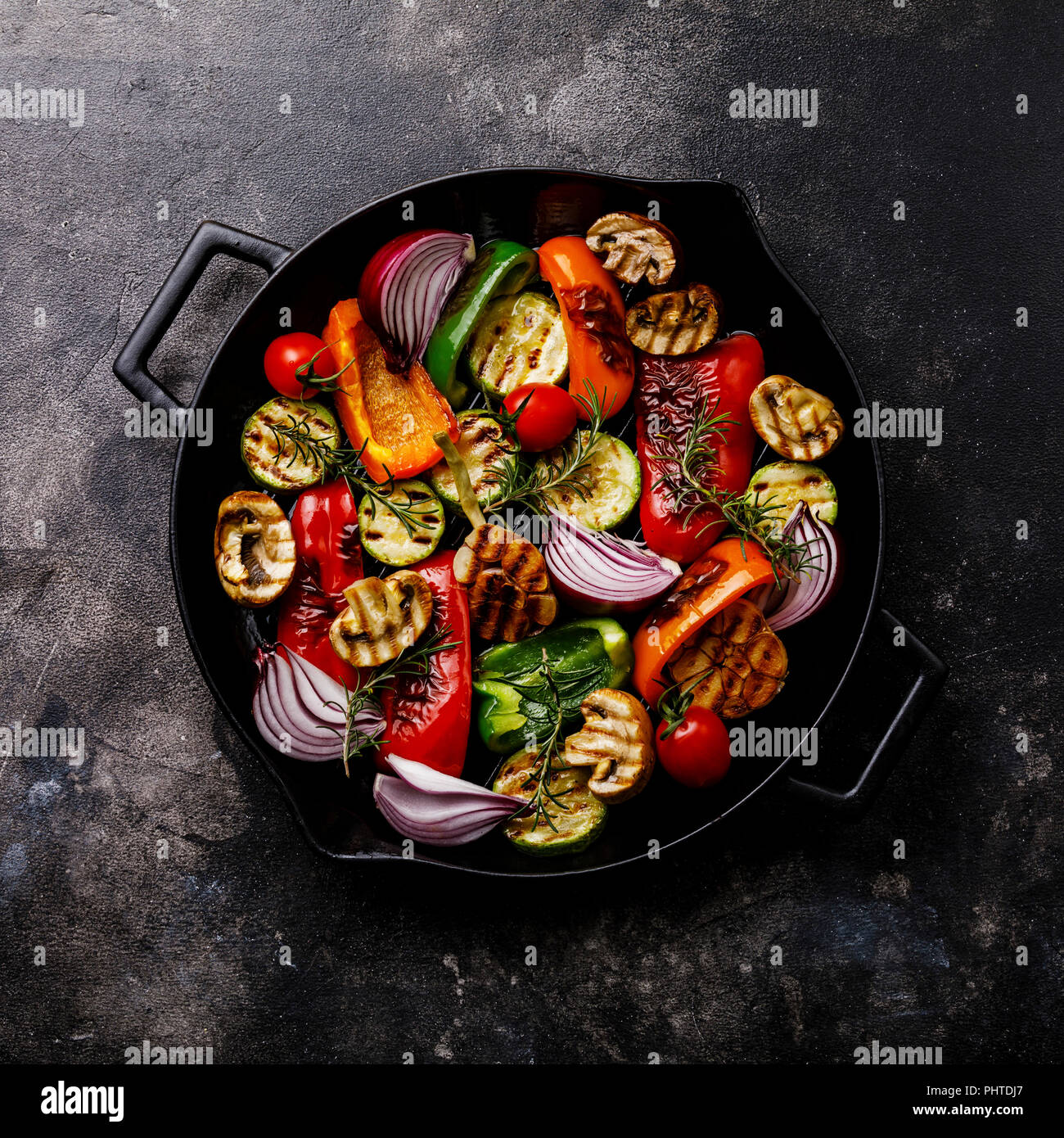 Grilled assorted vegetables in cast iron pan on dark background Stock ...