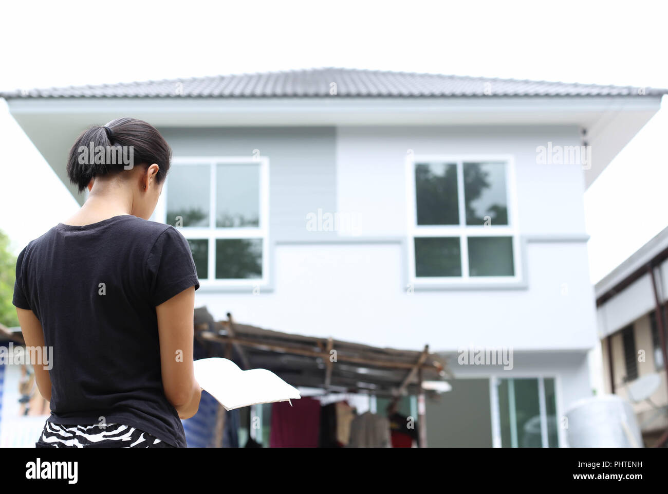 Asian woman look at the Blueprint at house Construction Stock Photo - Alamy