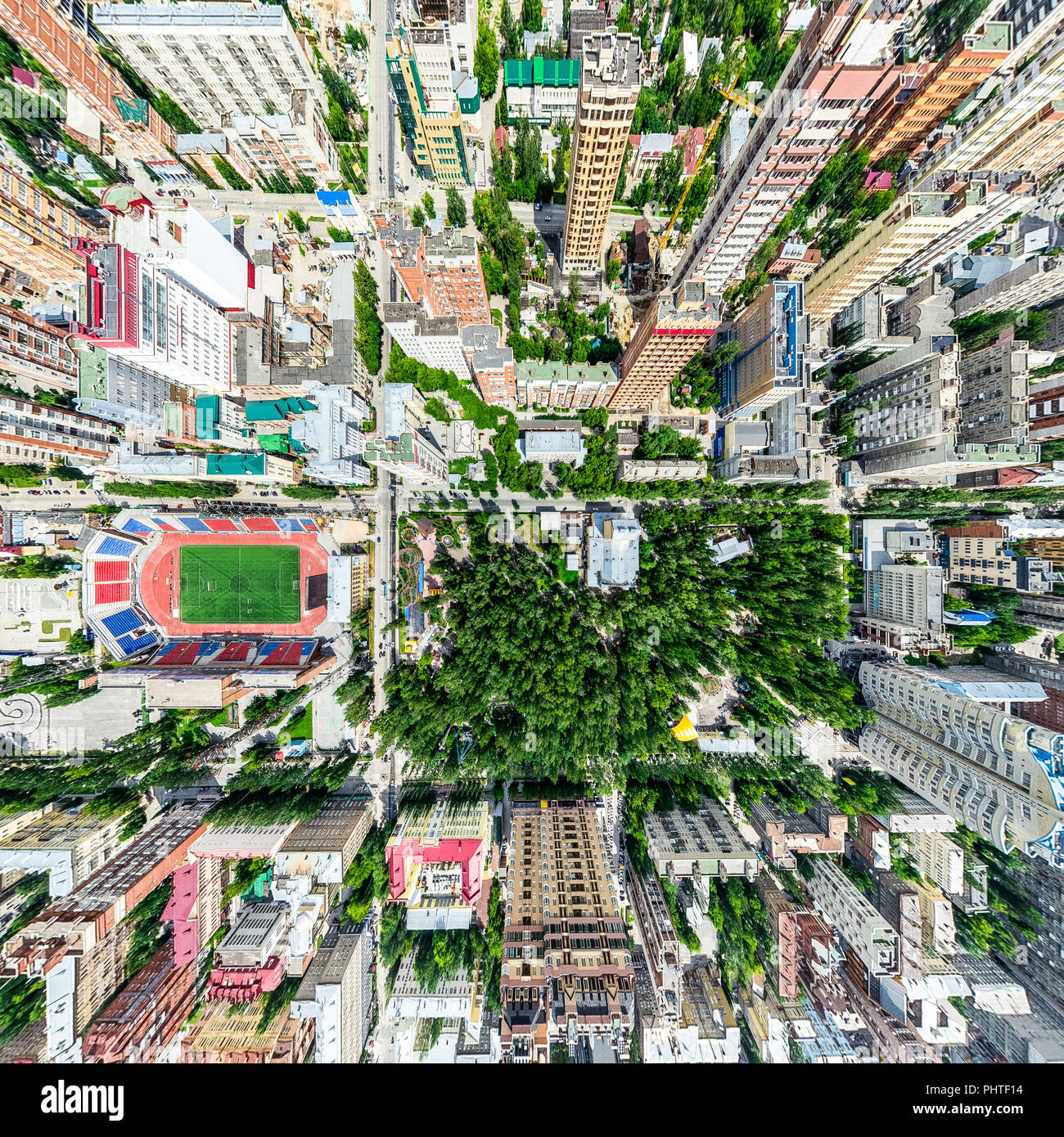 Aerial city view with crossroads and roads, houses, buildings, parks and parking lots. Sunny ...