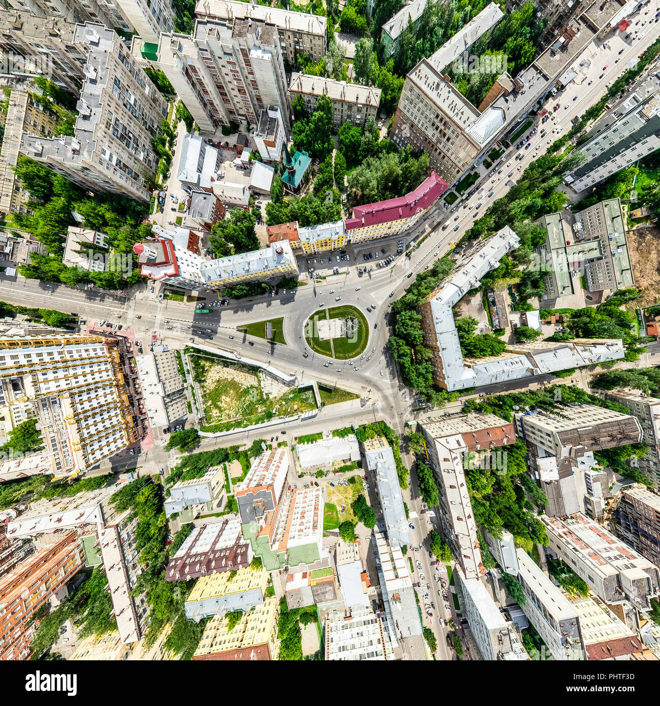 Aerial city view with crossroads and roads, houses, buildings, parks and parking lots. Sunny ...