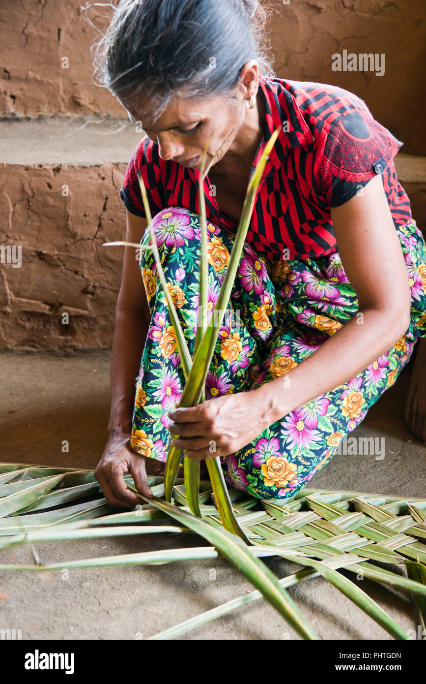 Vertical portrait of a lady weaving palm leaves Stock Photo - Alamy