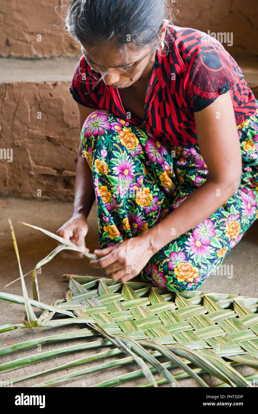 Vertical portrait of a lady weaving palm leaves Stock Photo - Alamy