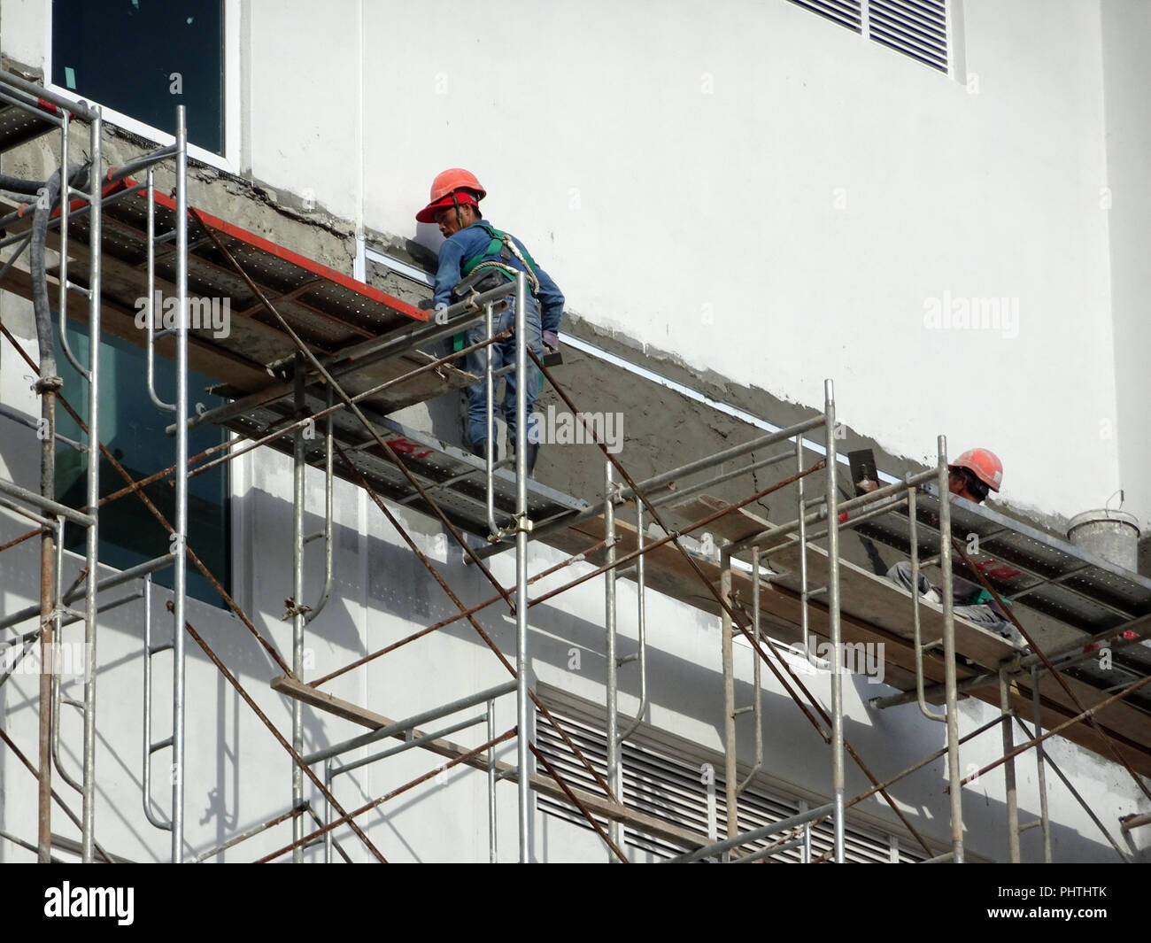 Construction workers plastering wall using cement plaster at the ...