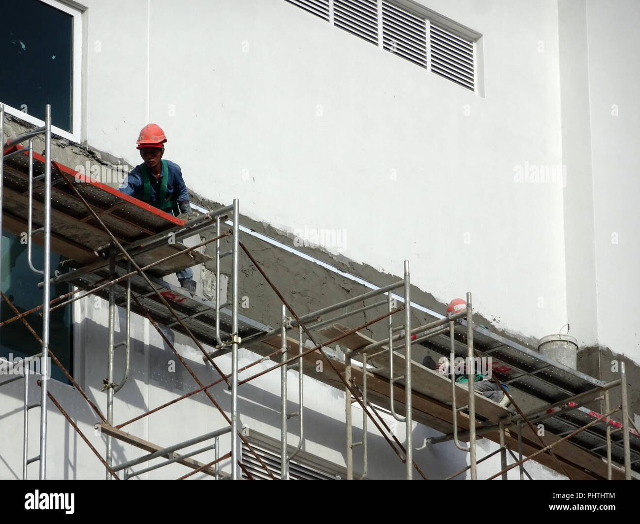 Construction workers plastering wall using cement plaster at the ...