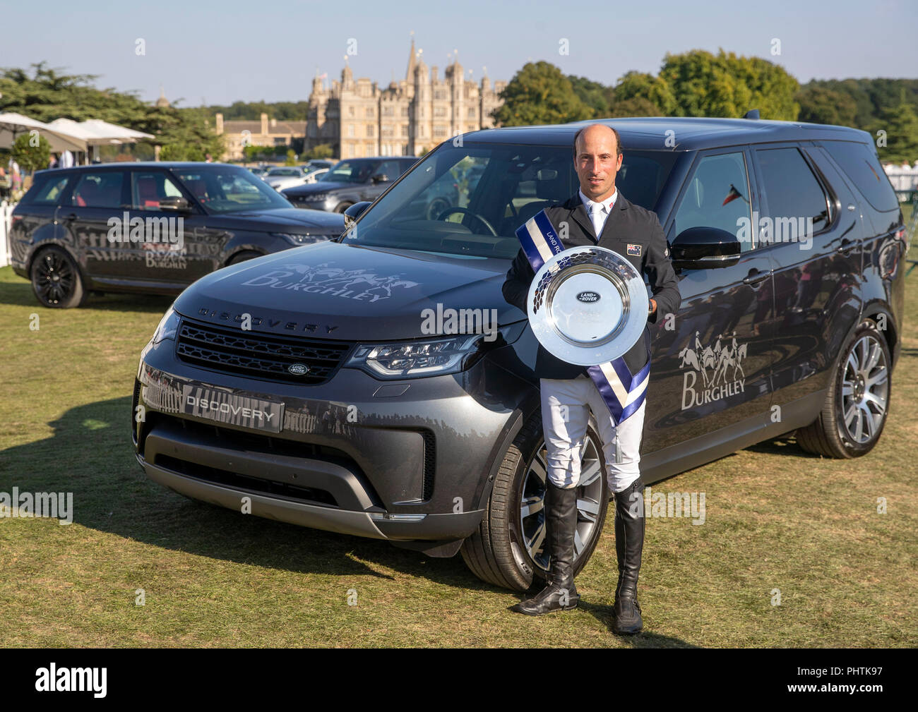 New Zealand's Tim Price poses with his trophy on a Land Rover Discovery ...