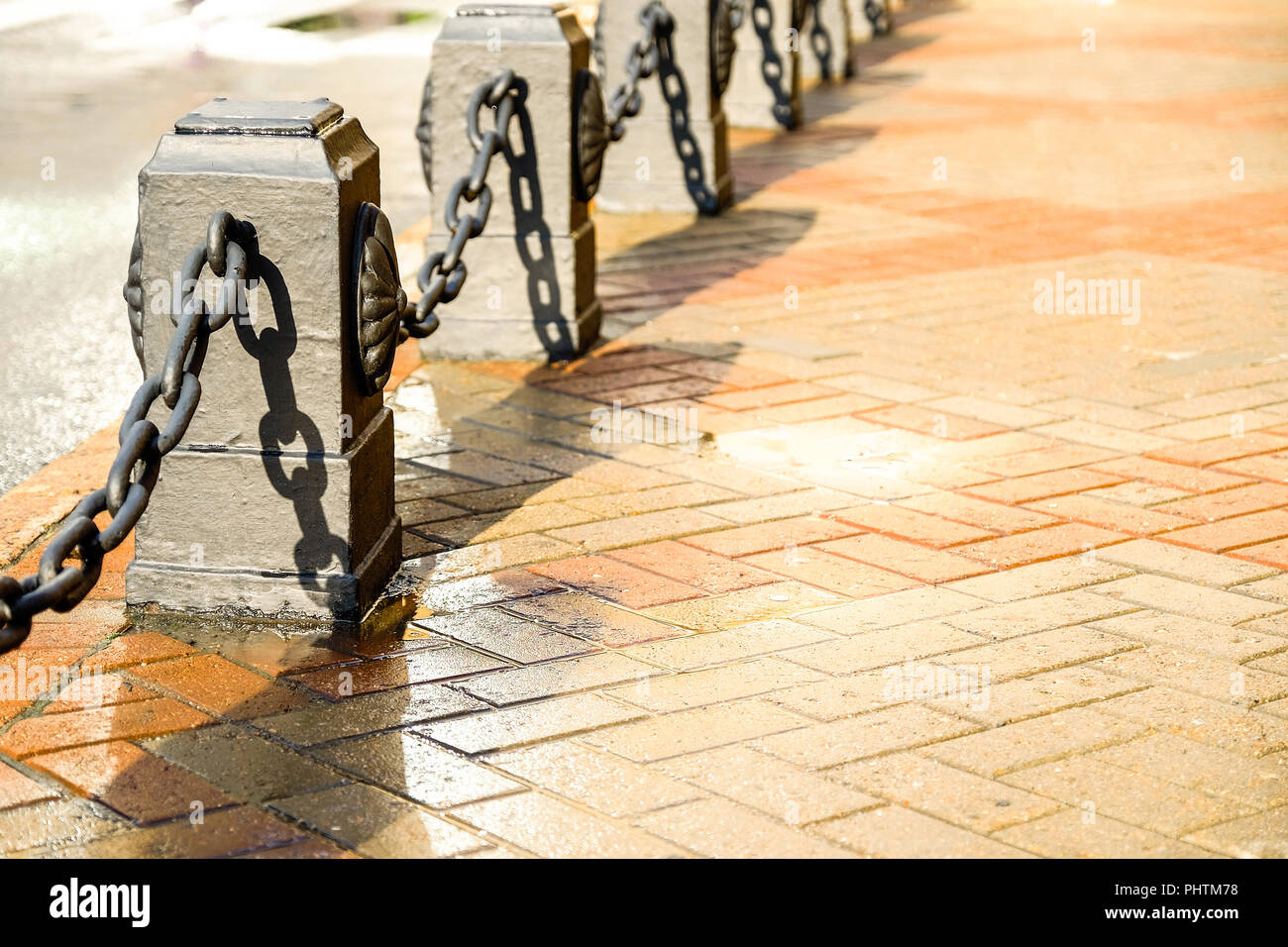 Fence with chains. Chain fence in the background of the road. paving ...