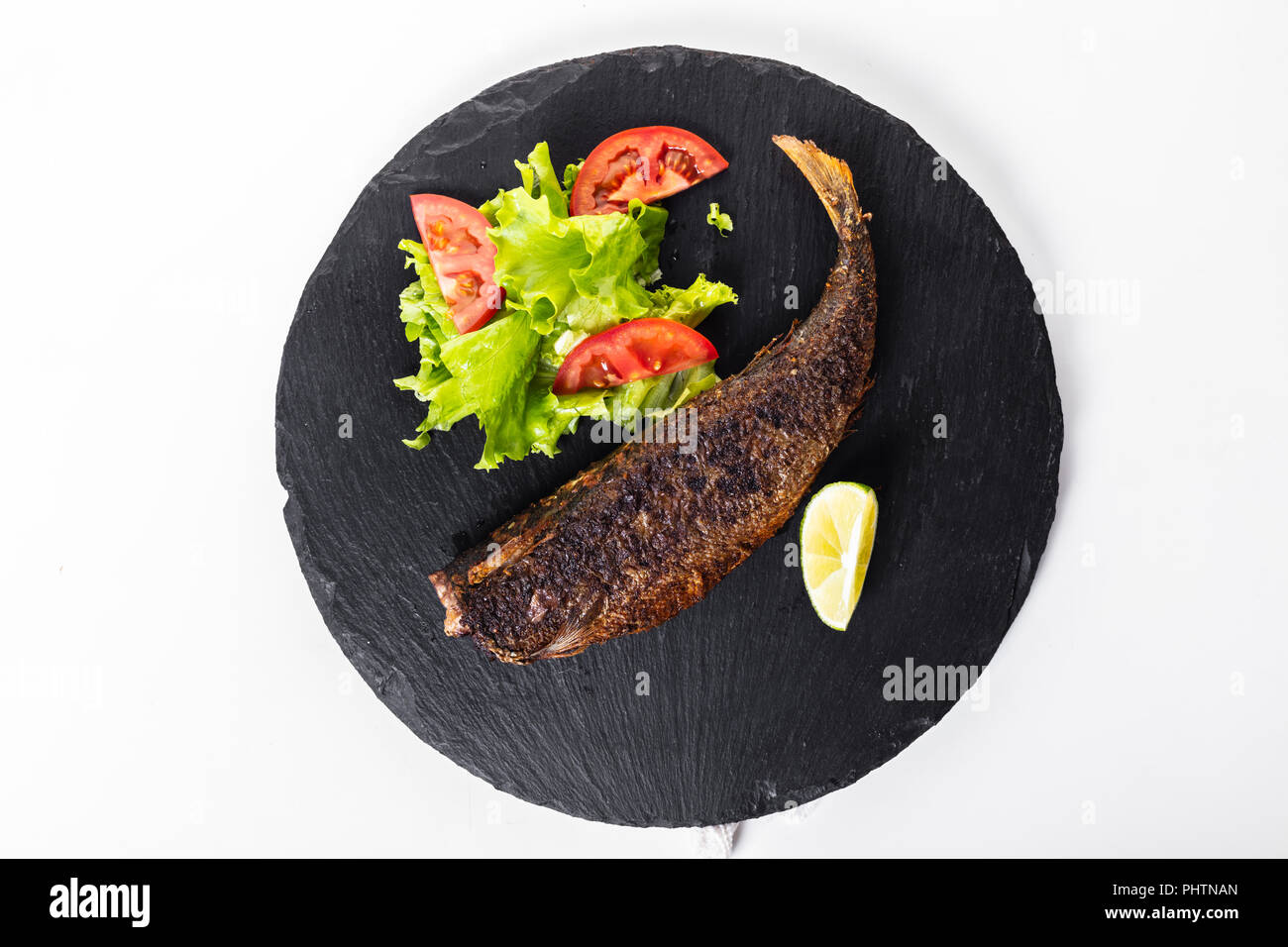 cooked fish with vegetables on white background Stock Photo - Alamy
