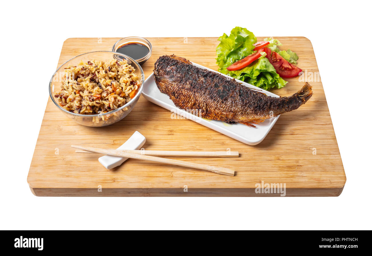 cooked fish with rice and vegetables on white isolated background Stock ...