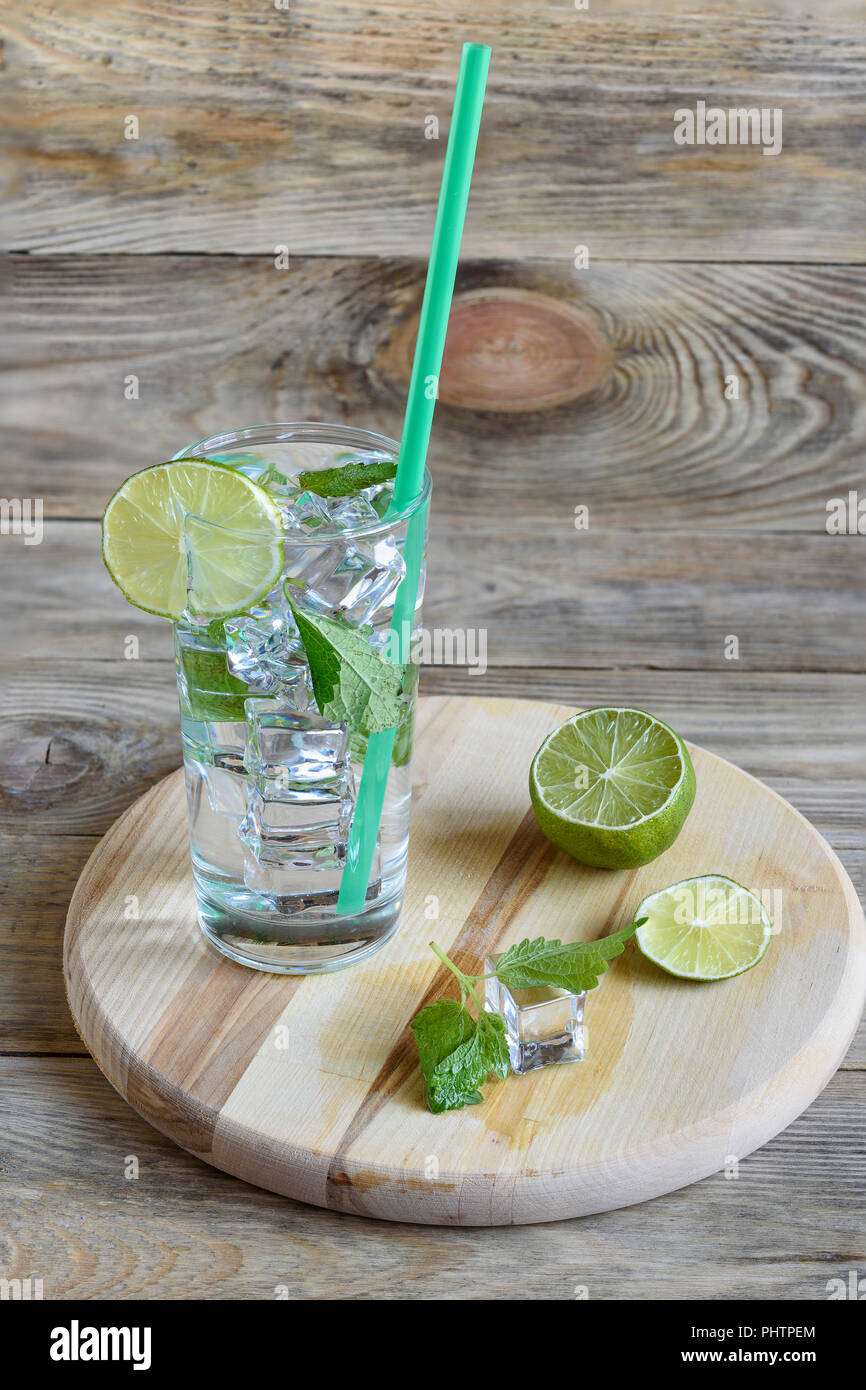Cocktail, lime, melissa leaves, ice cubes on wooden background Stock ...