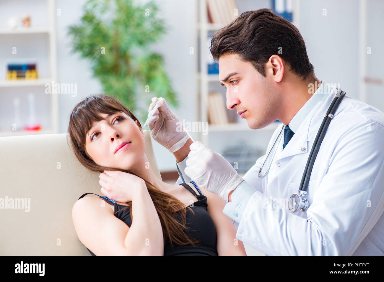 Doctor checking patients ear during medical examination Stock Photo - Alamy