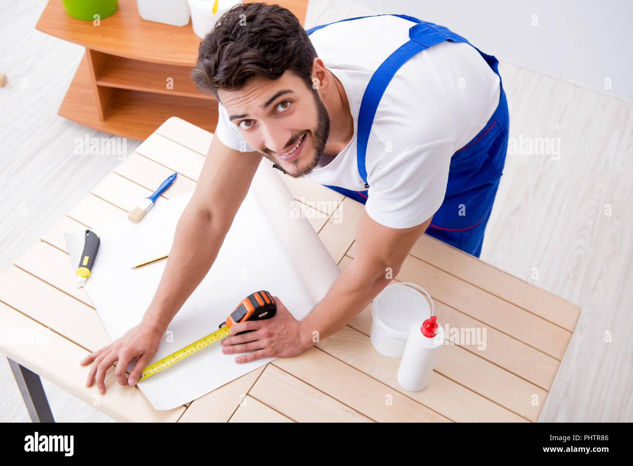 Worker working on wallpaper during refurbishment Stock Photo - Alamy