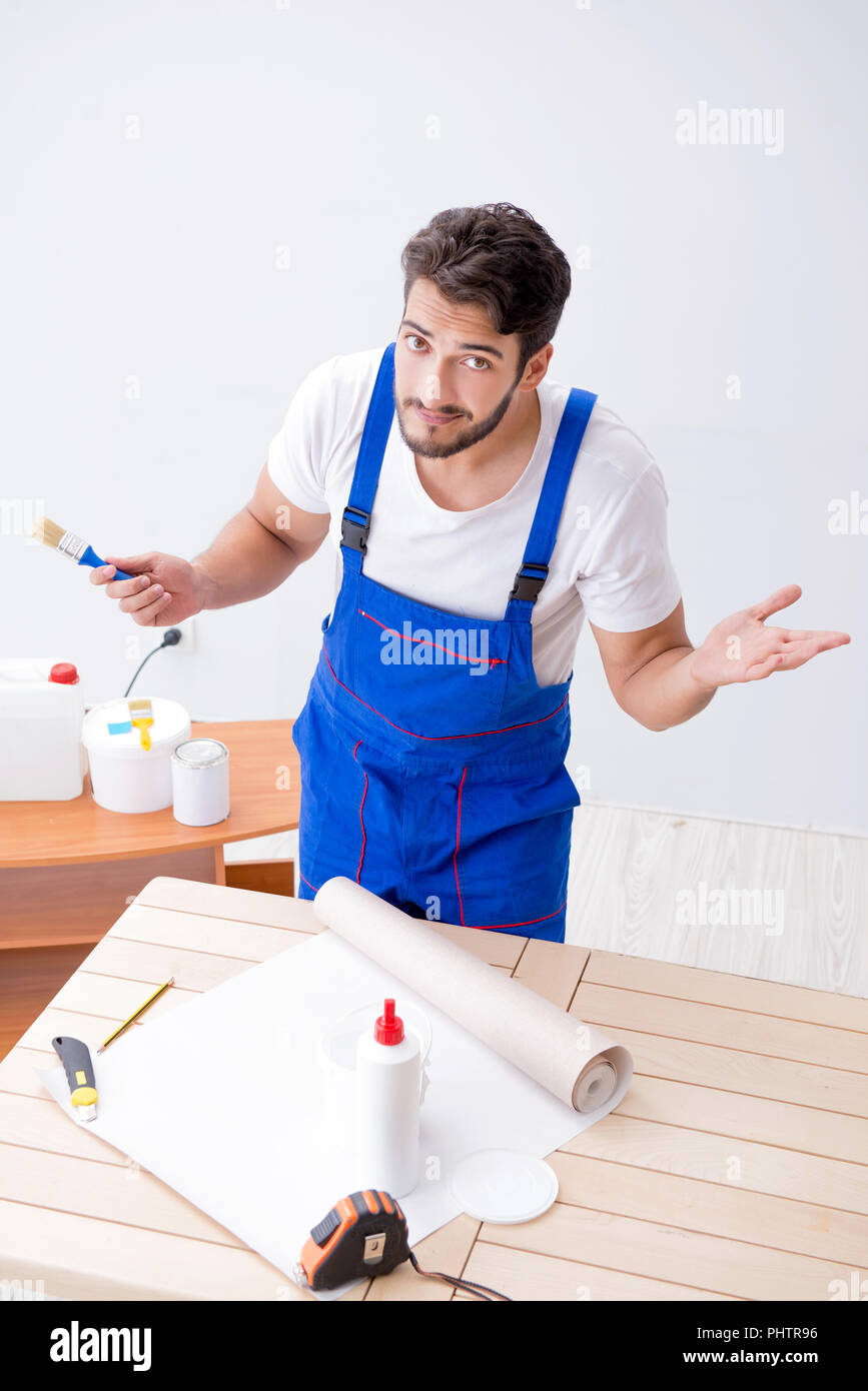 Worker working on wallpaper during refurbishment Stock Photo - Alamy