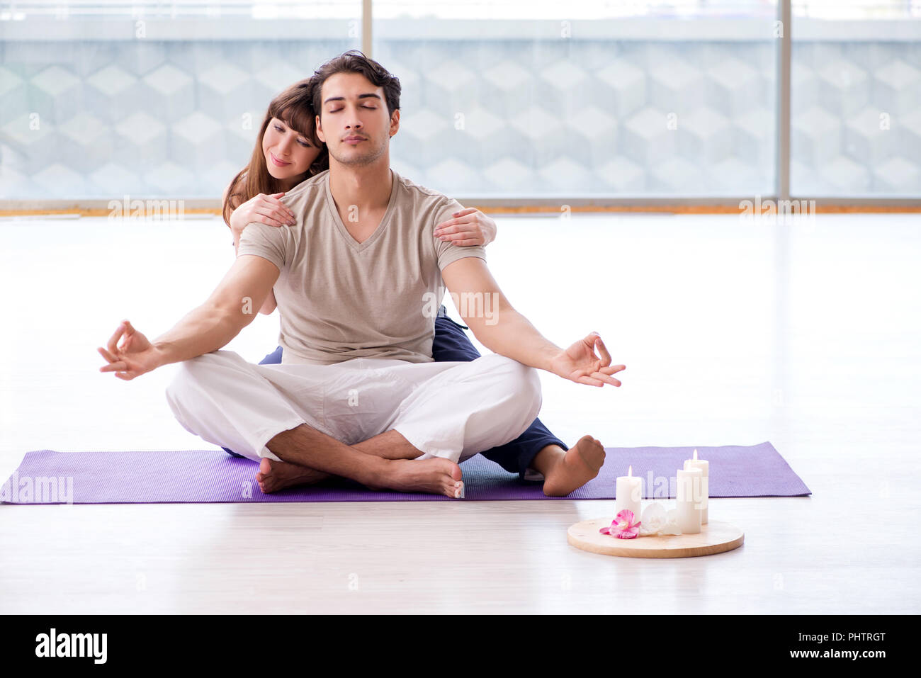 Personal coach helping during yoga session Stock Photo - Alamy