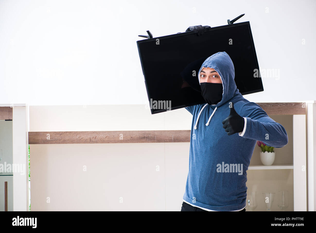 Man burglar stealing tv set from house Stock Photo - Alamy