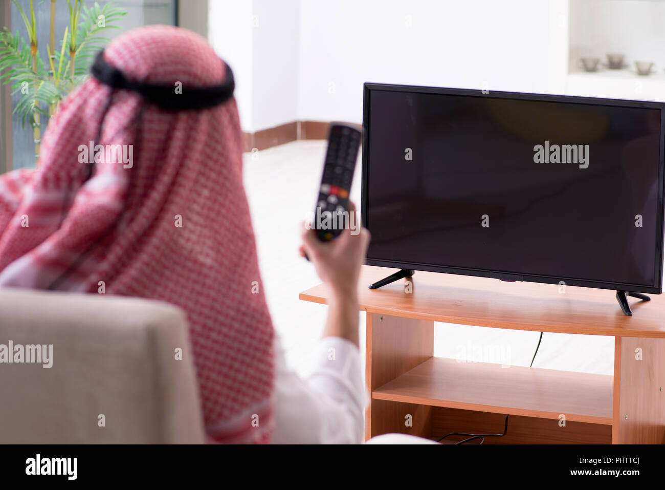 Arab man watching tv at home Stock Photo - Alamy