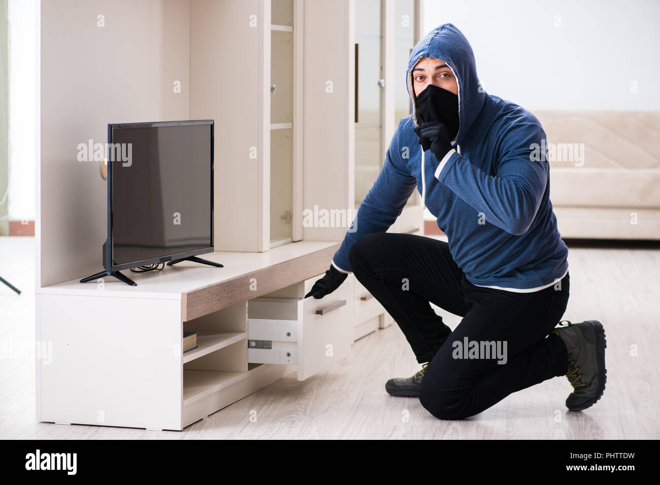 Man burglar stealing tv set from house Stock Photo - Alamy