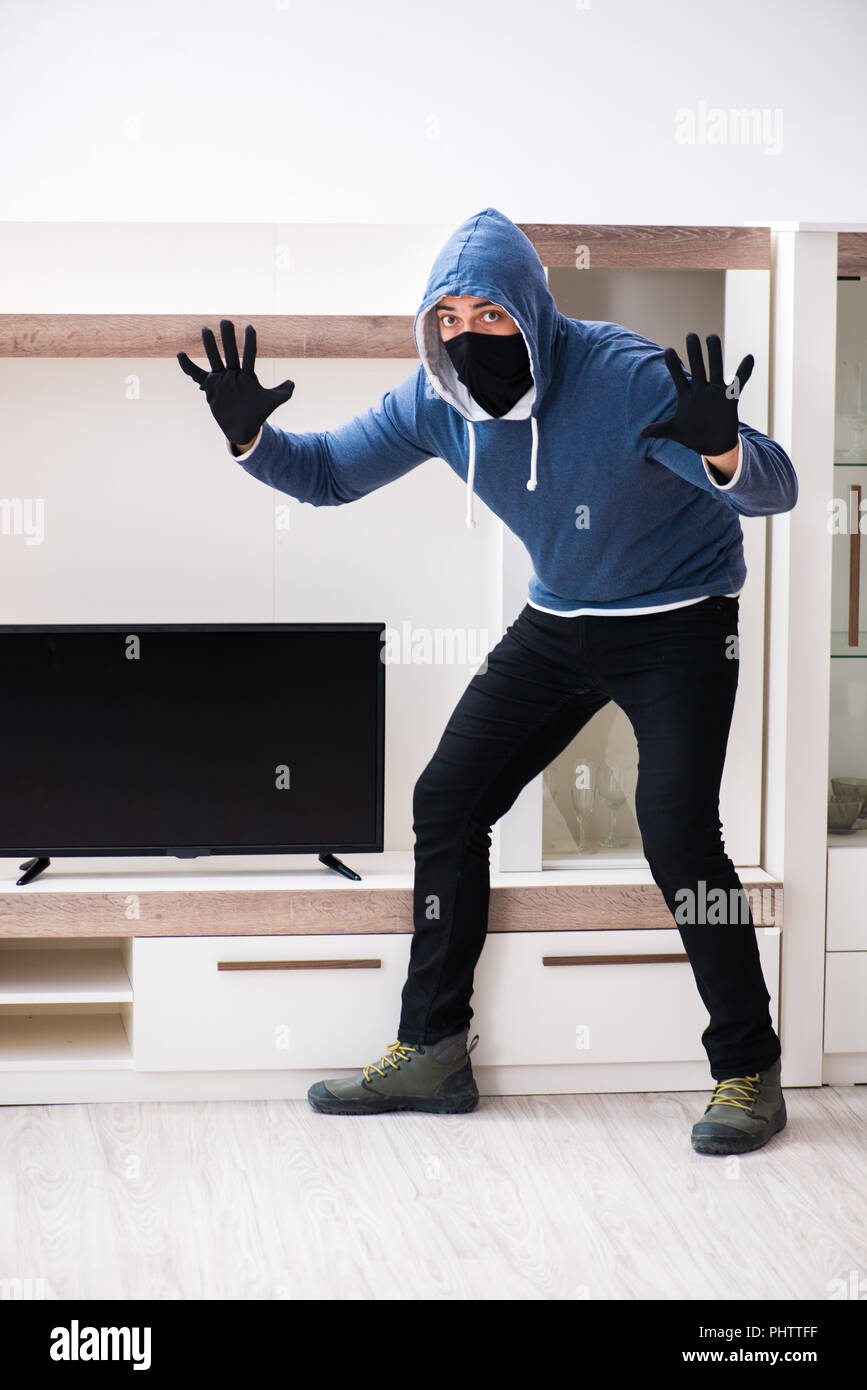 Man burglar stealing tv set from house Stock Photo - Alamy