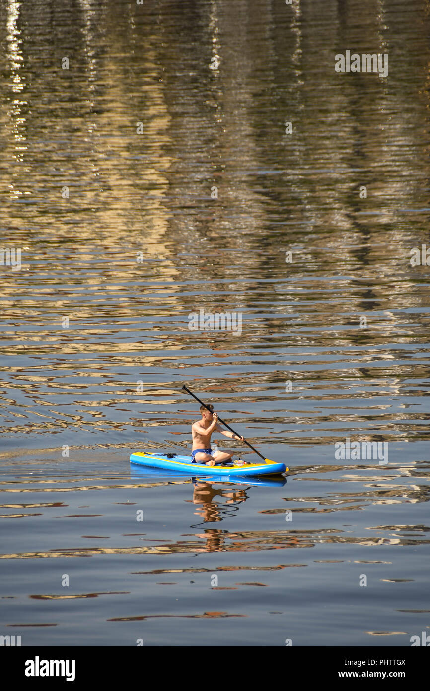 Person paddle boarding on the River Vltava in the centre of Prague ...