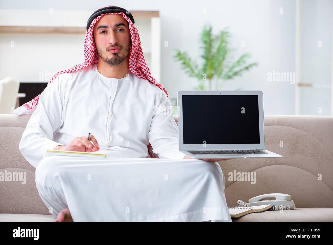 Arab man working at home on his work Stock Photo - Alamy