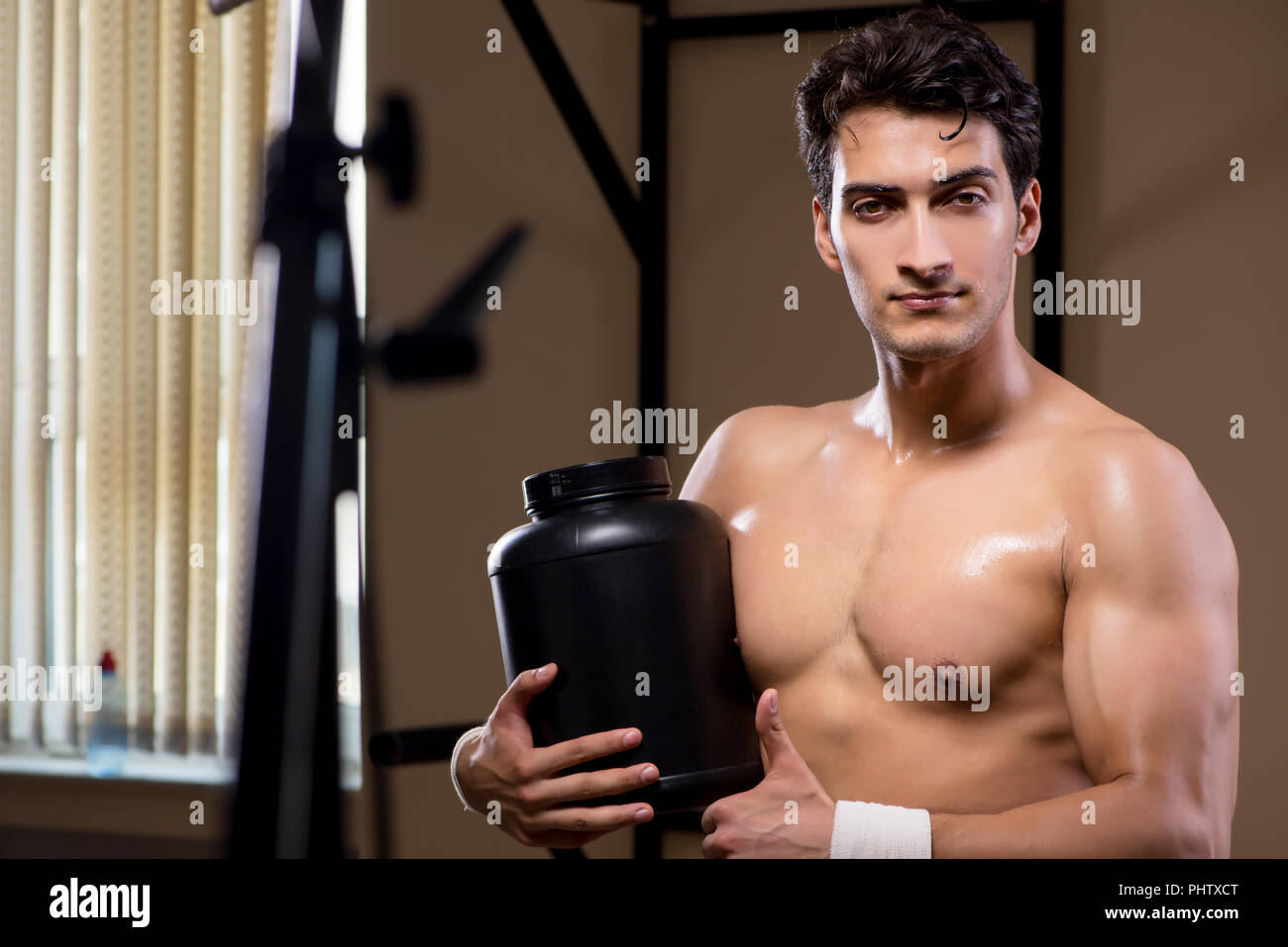 Man with nutrient supplements in sports gym Stock Photo - Alamy