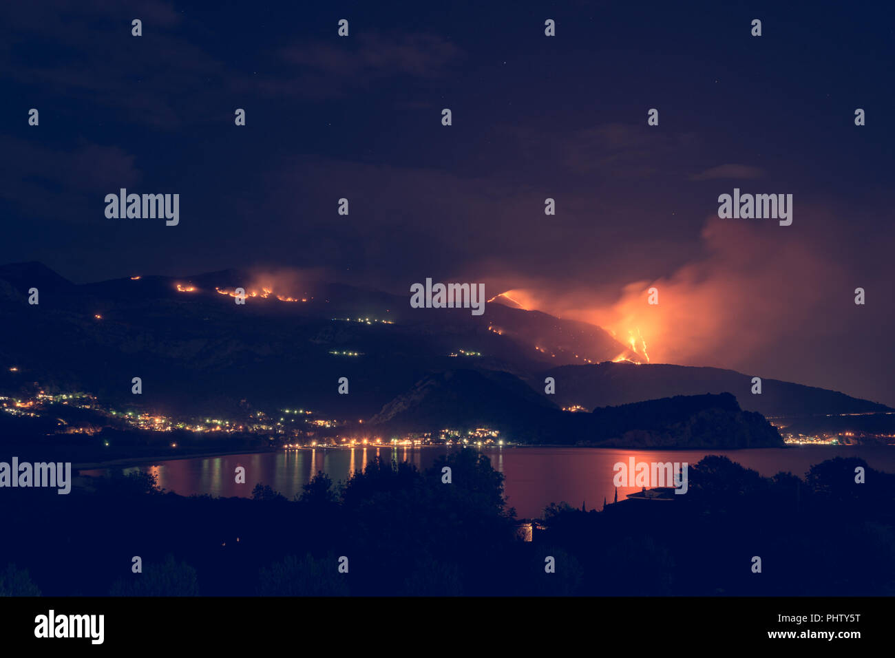 Wild fire blazing on hills above sea town Stock Photo - Alamy