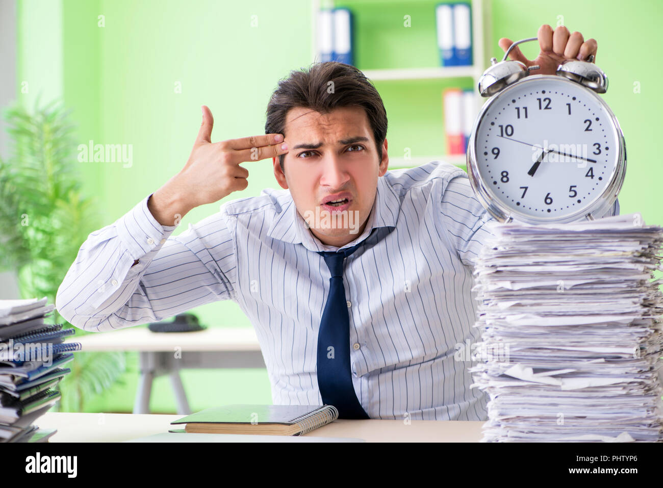 Businessman having problems with paperwork and workload Stock Photo - Alamy