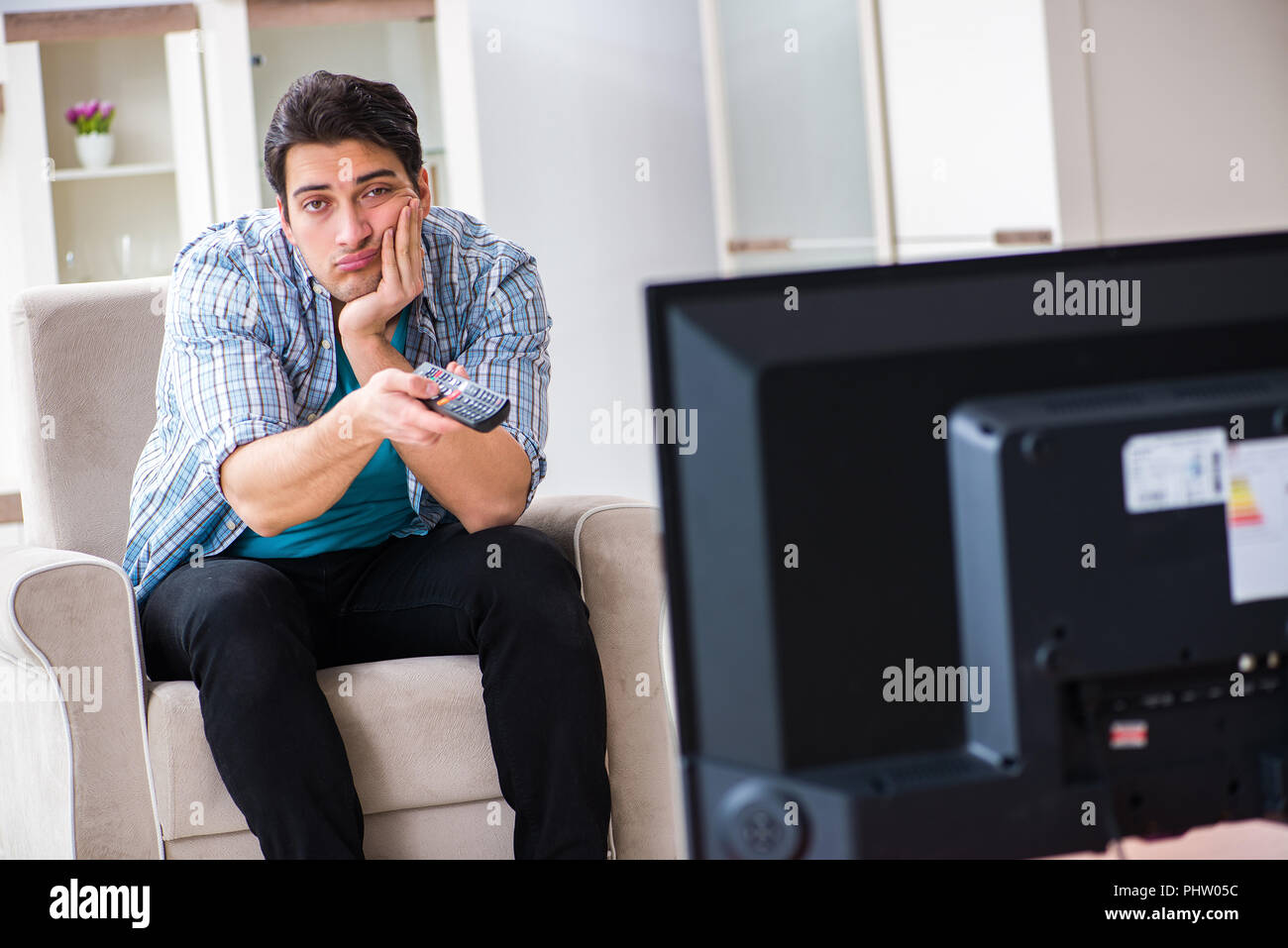 Man watching tv at home Stock Photo - Alamy