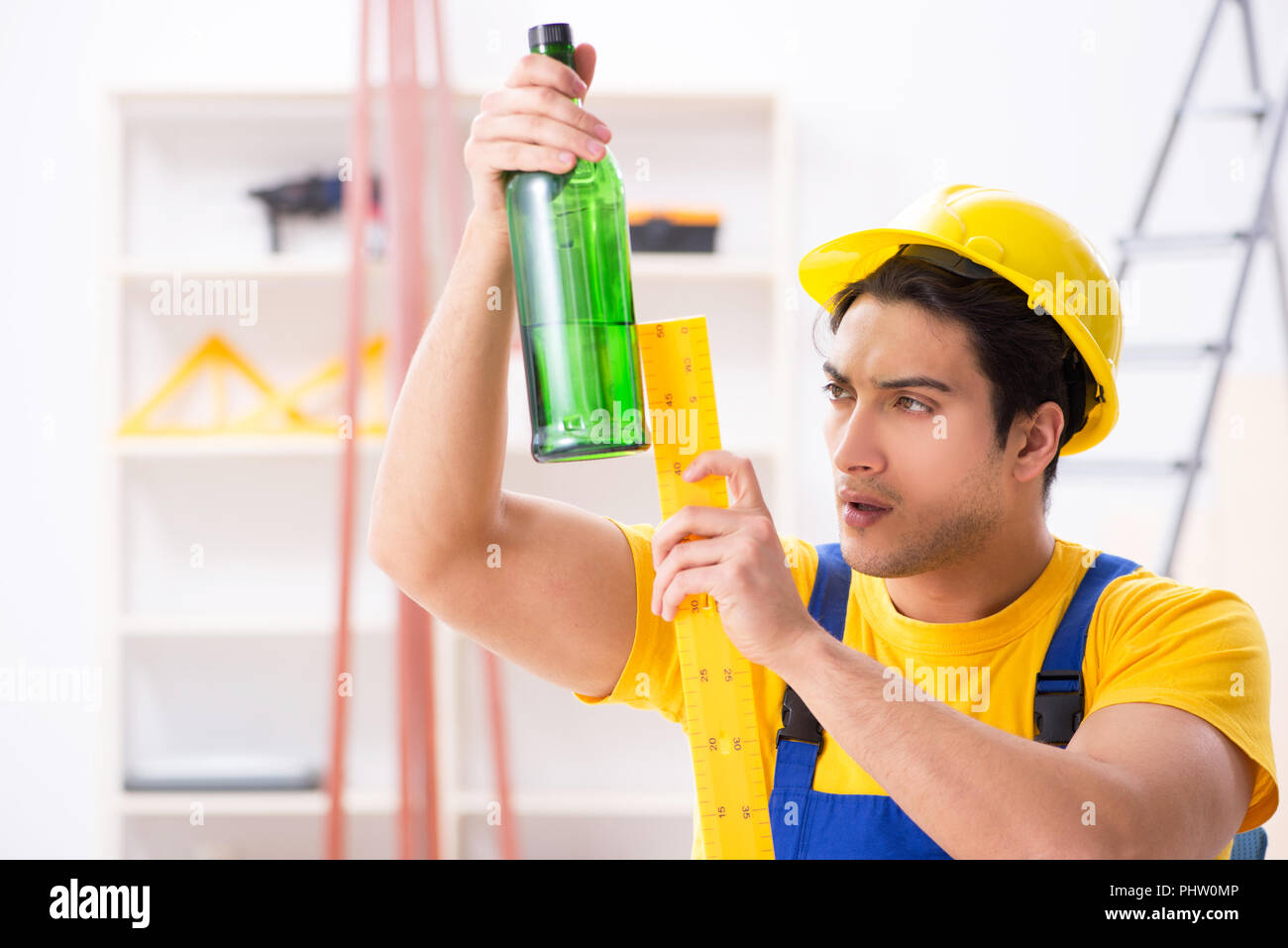 Drunk engineer working in the workshop Stock Photo - Alamy