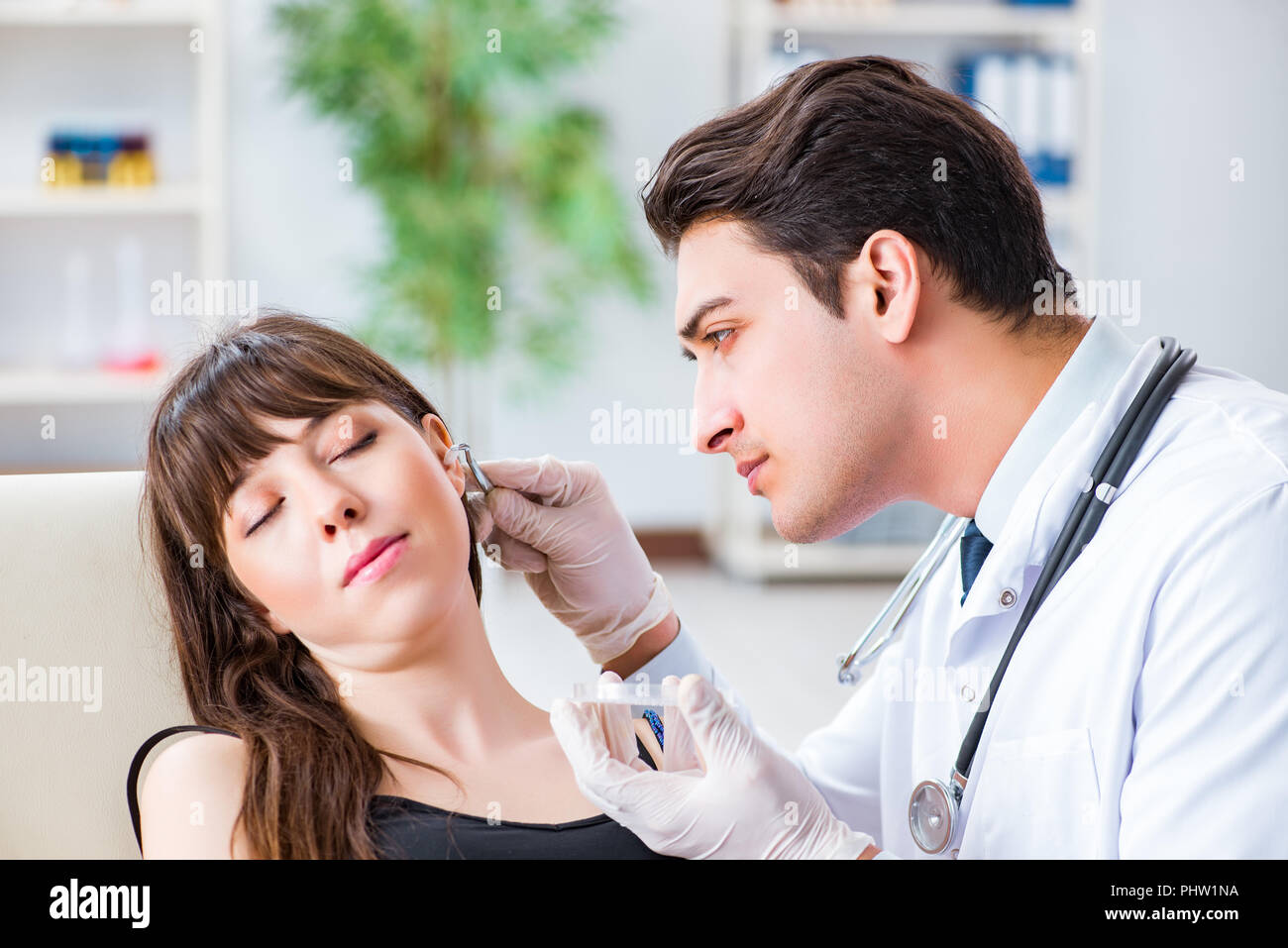 Doctor checking patients ear during medical examination Stock Photo - Alamy