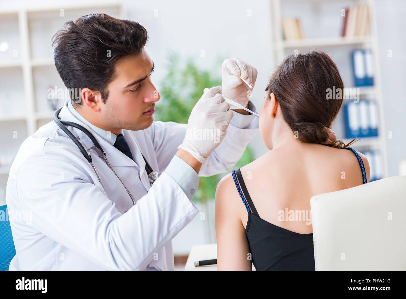 Doctor checking patients ear during medical examination Stock Photo - Alamy