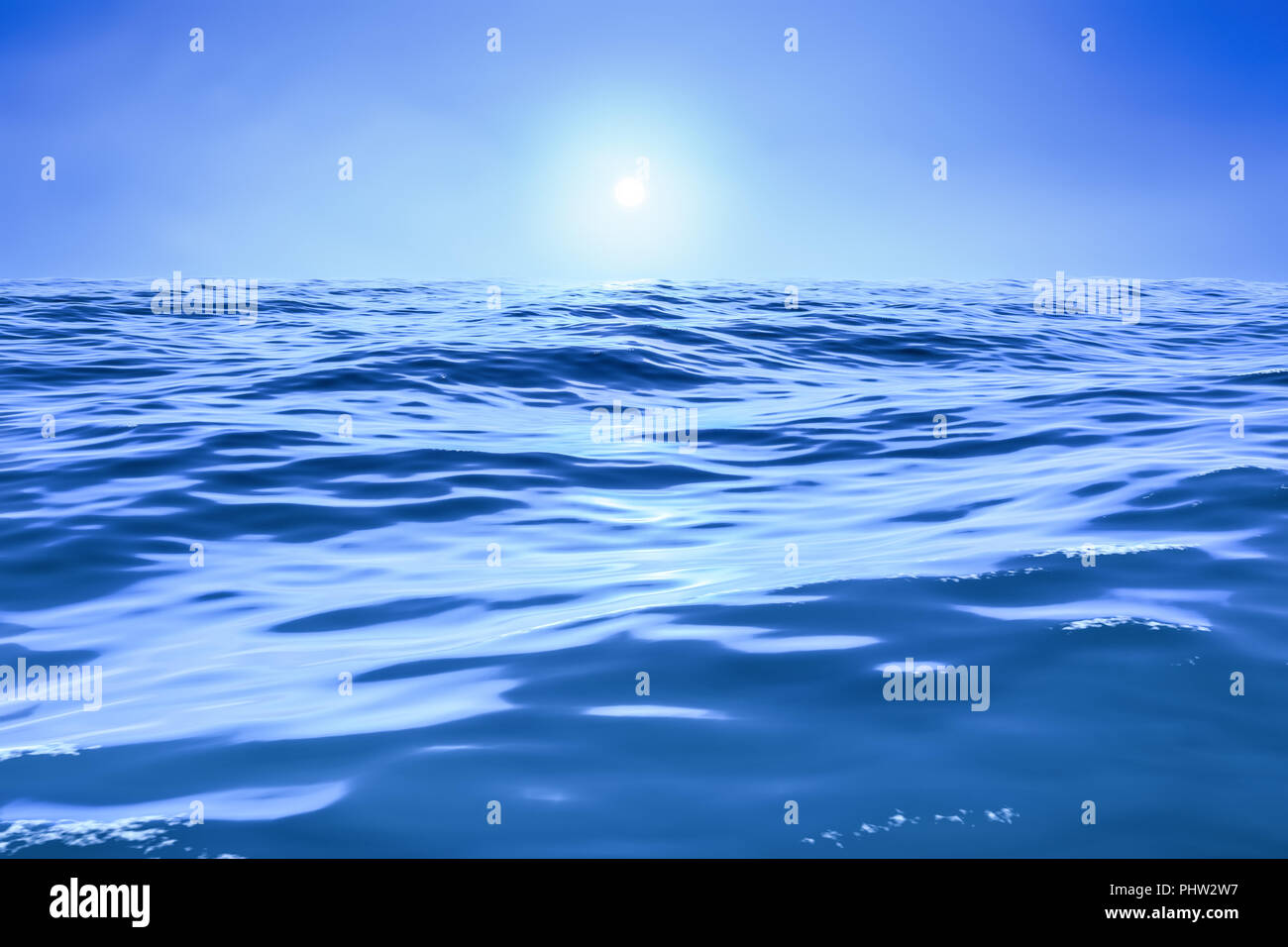 a blue ocean with sun over the horizon Stock Photo - Alamy
