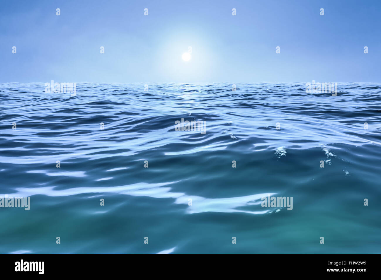 a blue ocean with sun over the horizon Stock Photo - Alamy
