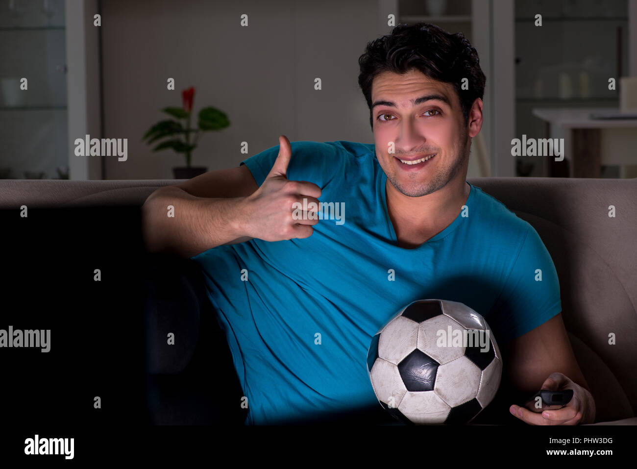 Young man watching football late at night Stock Photo - Alamy