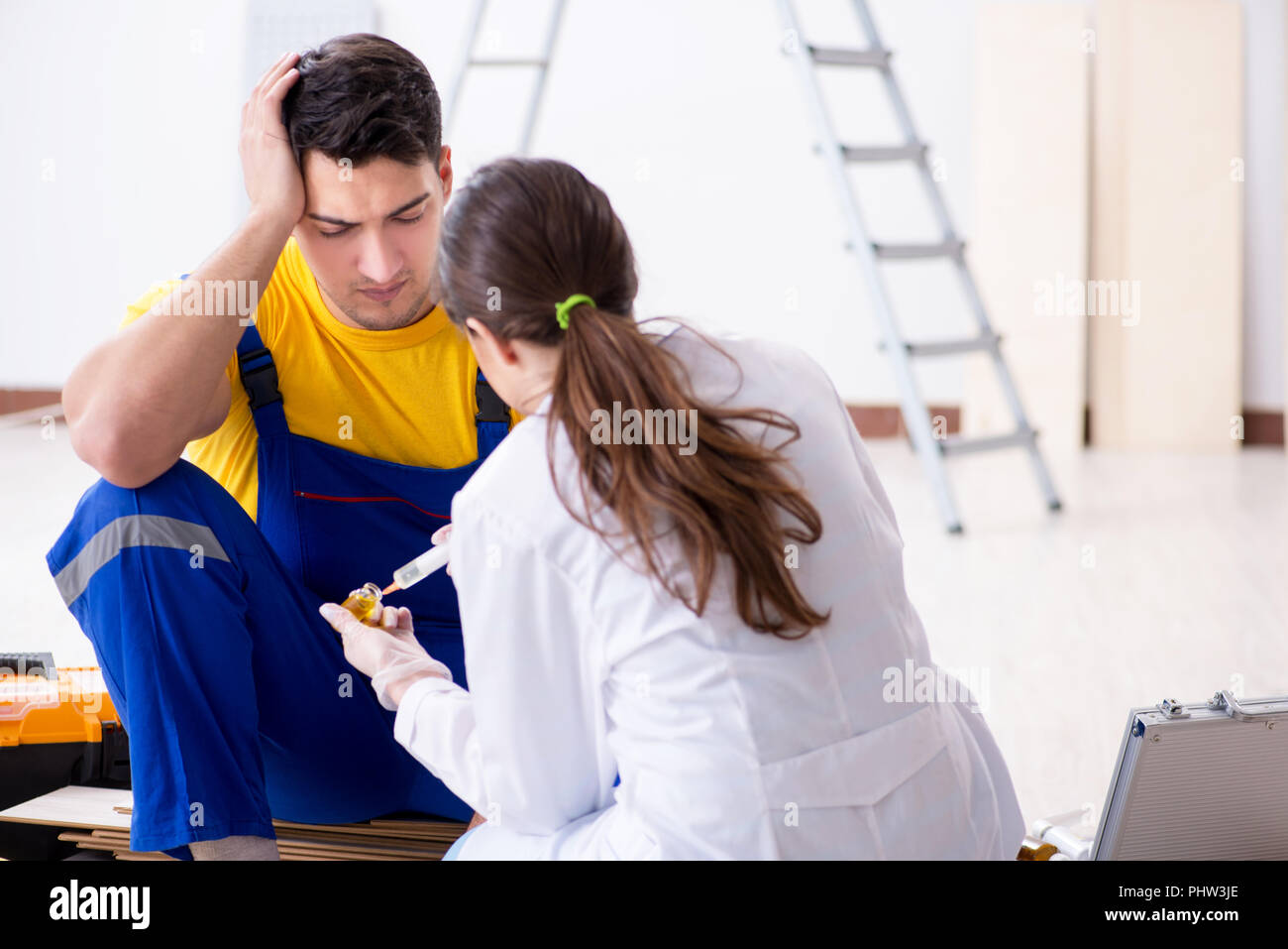 Doctor helping injured worker at construction site Stock Photo - Alamy