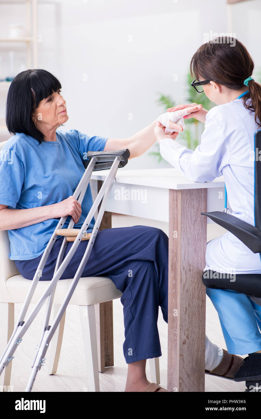 Doctor examining old mature woman after incident Stock Photo - Alamy